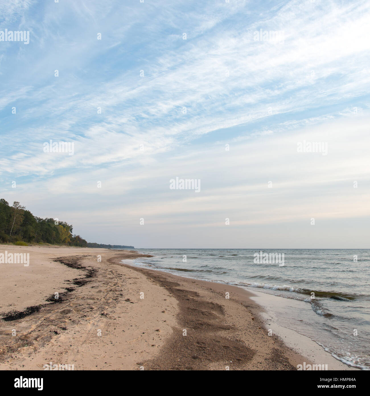 Shoreline of Baltic sea beach with rocks and sand dunes under clouds ...