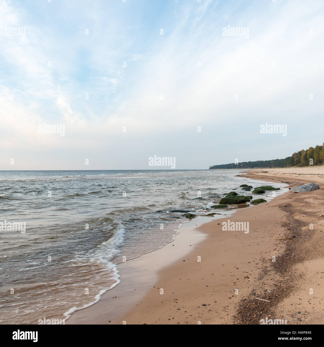 Shoreline of Baltic sea beach with rocks and sand dunes under clouds ...