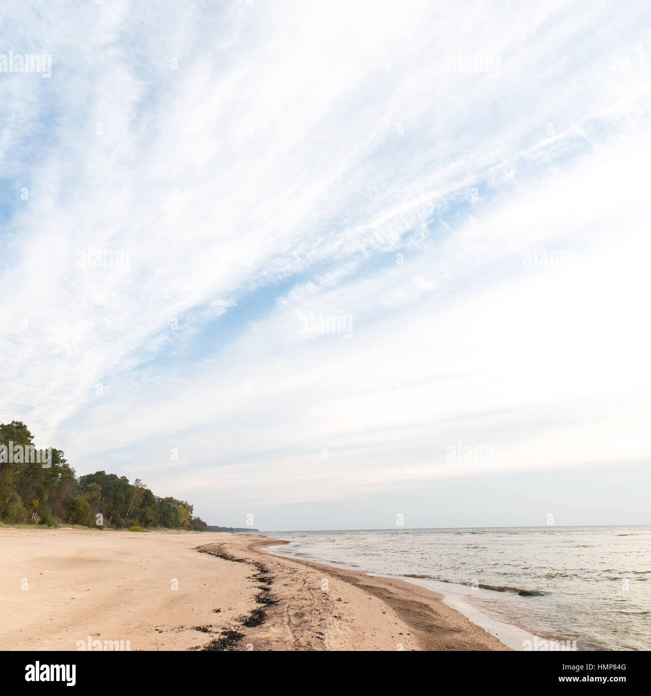 Shoreline of Baltic sea beach with rocks and sand dunes under clouds ...