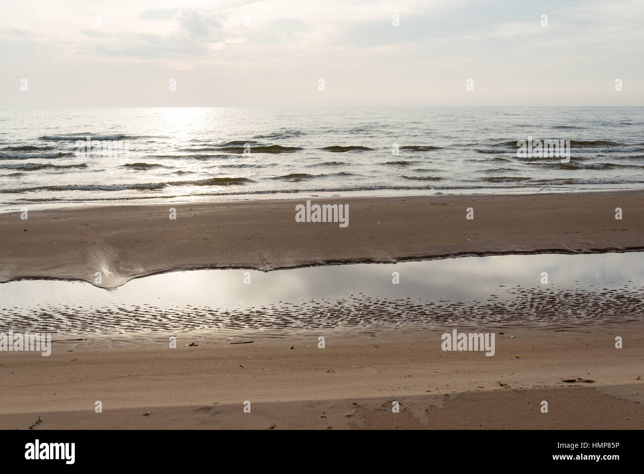 Shoreline of Baltic sea beach with rocks and sand dunes under clouds ...
