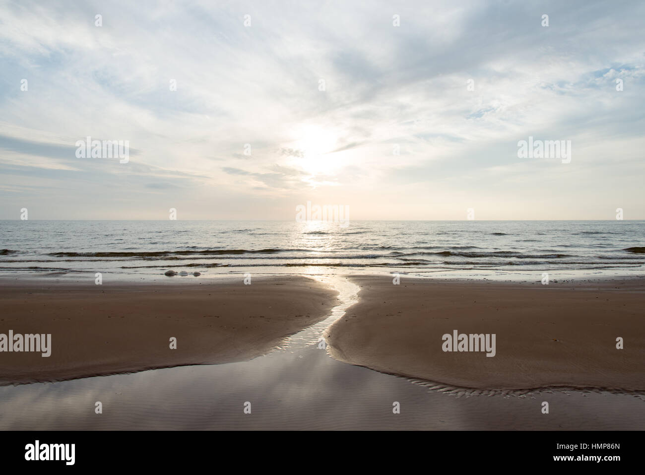 Shoreline of Baltic sea beach with rocks and sand dunes under clouds ...
