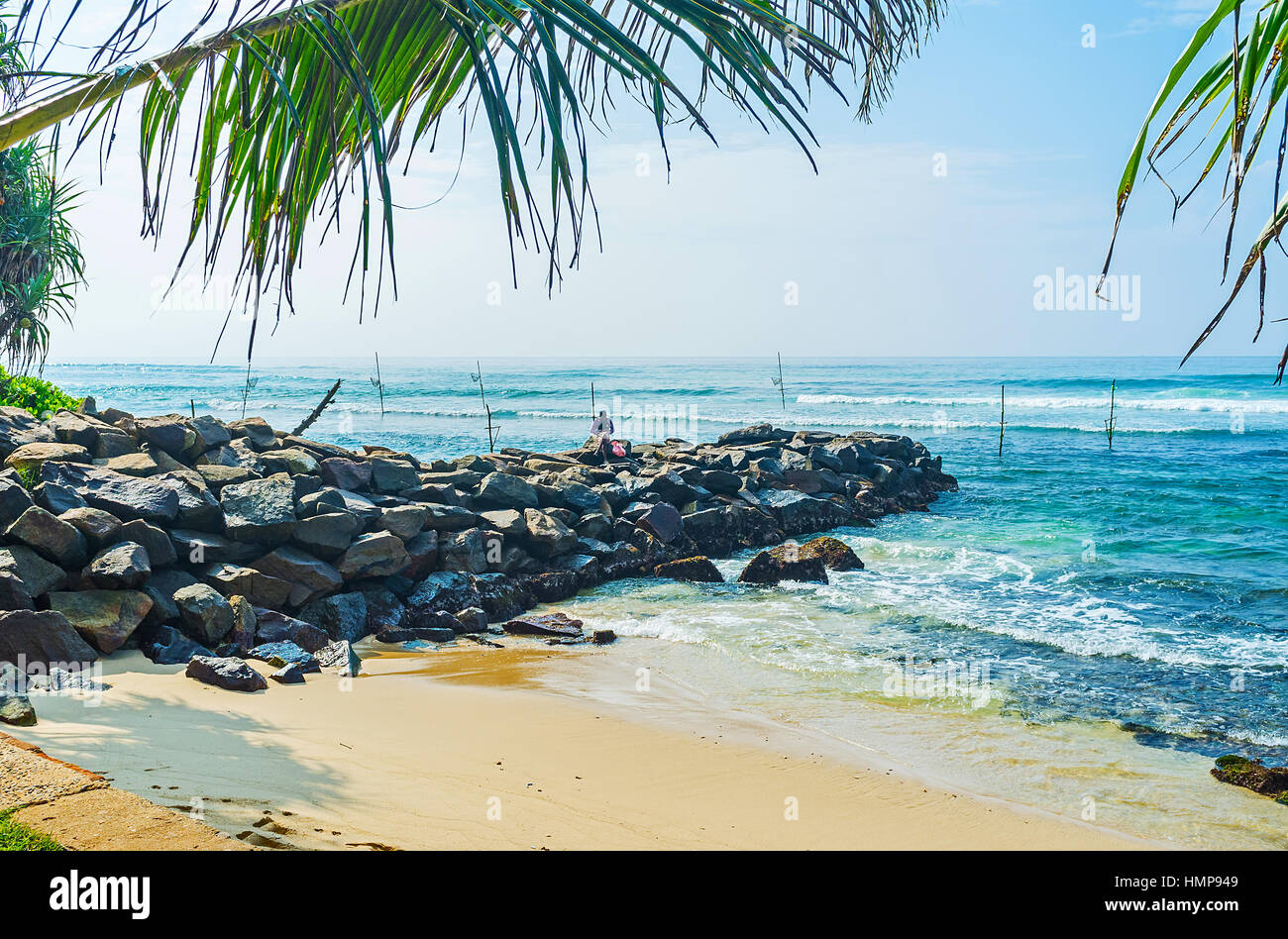 The sandy Ahangama beach with fishermen's sticks and shady palms, Sri ...