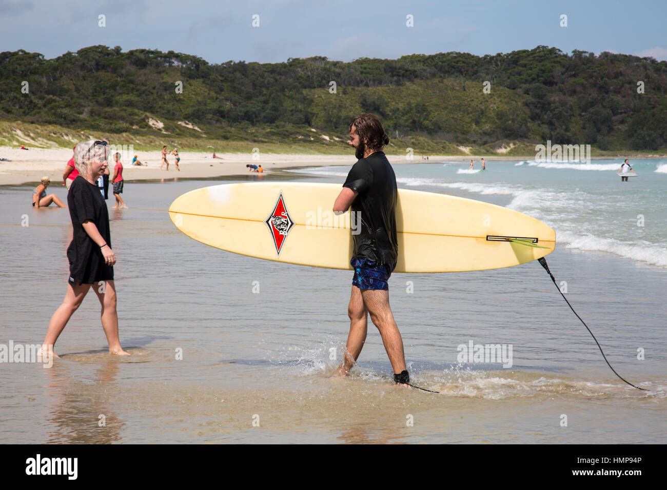 Man carrying his surfboard at Cave Beach,popular small surf beach ...