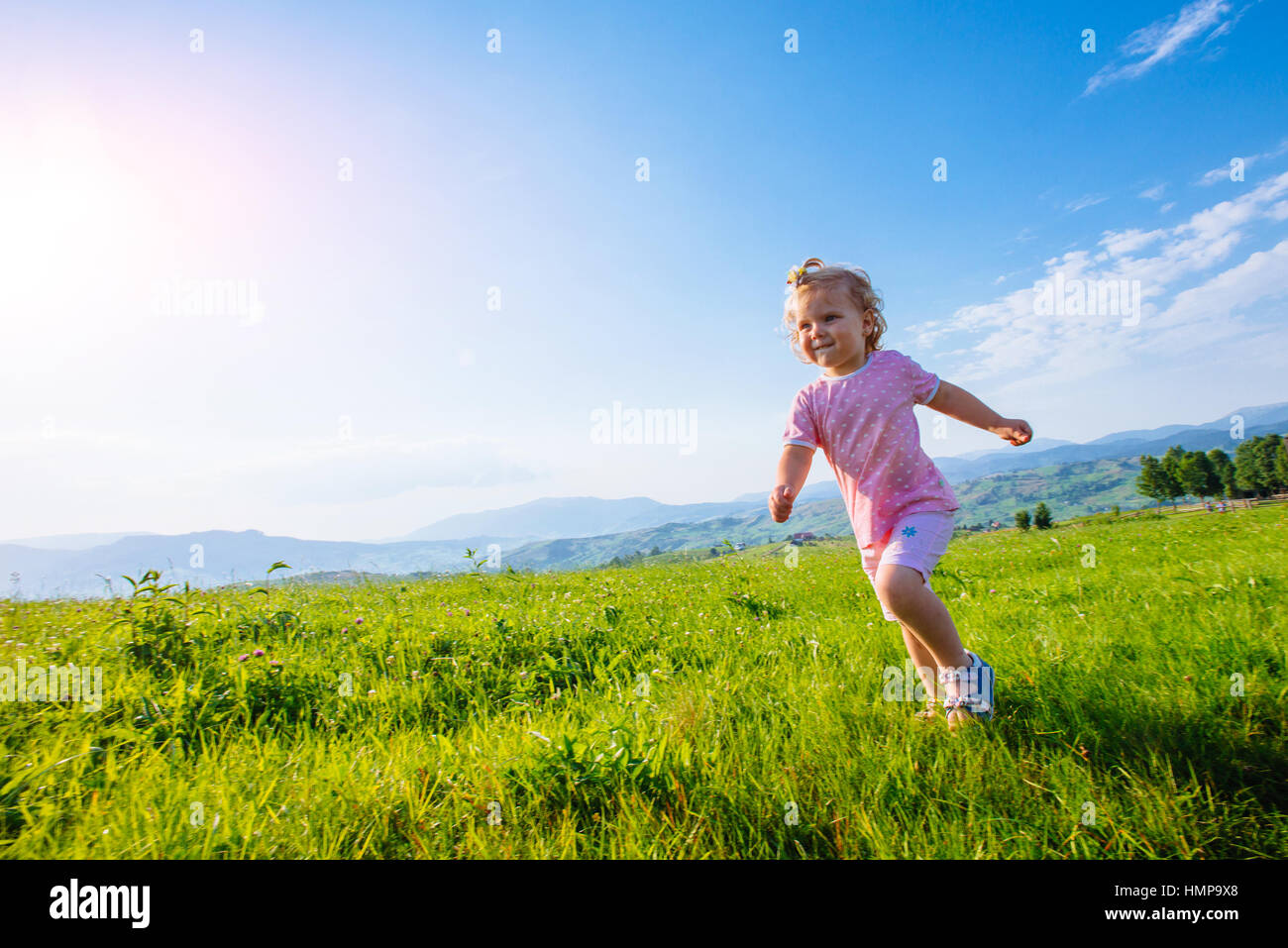 Little toddler girl running in a beautiful field Stock Photo - Alamy