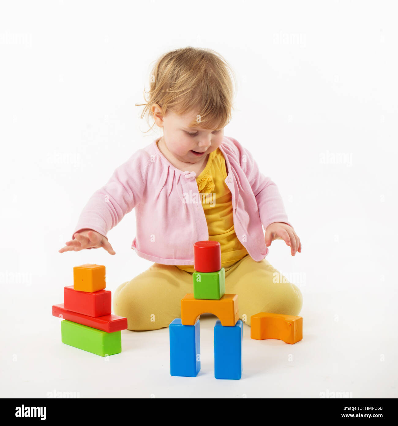 little girl playing with colorful toy blocks Stock Photo - Alamy