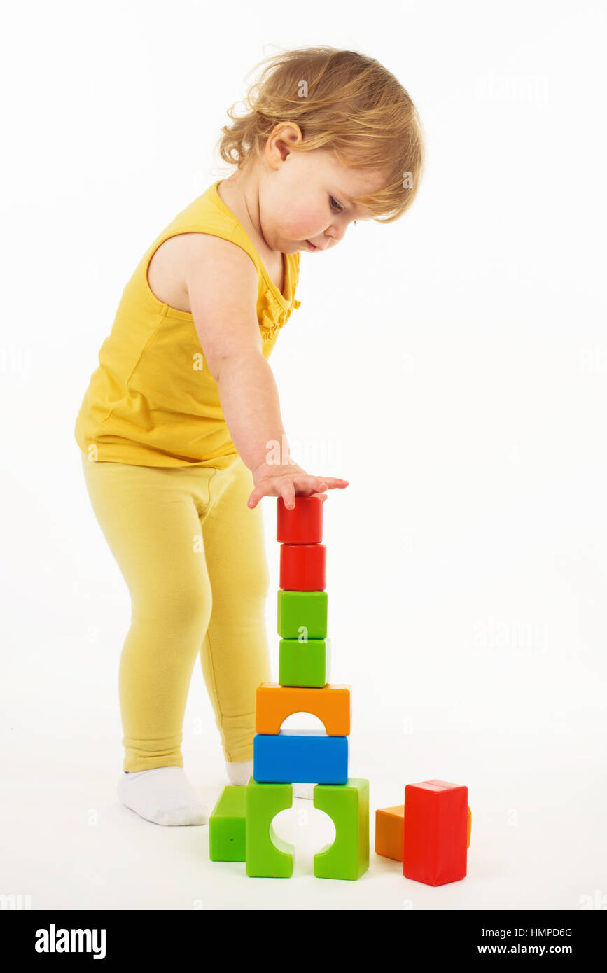 little girl playing with colorful toy blocks Stock Photo - Alamy