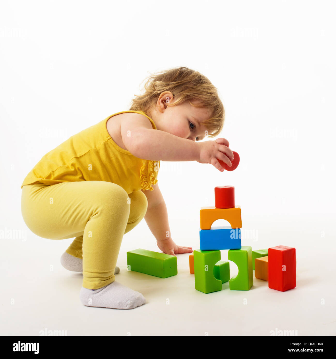 little girl playing with colorful toy blocks Stock Photo - Alamy