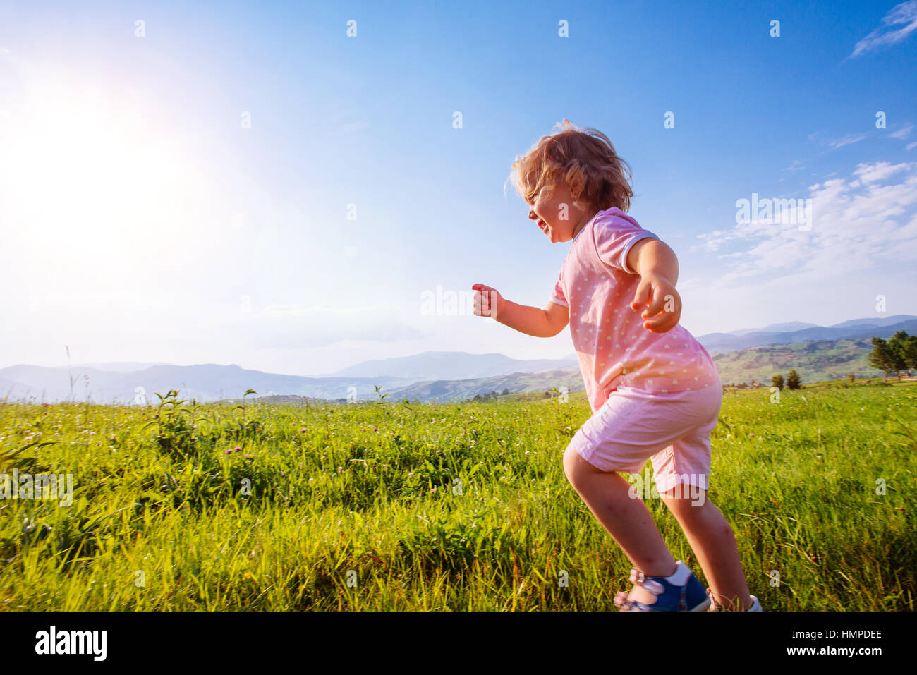 Little toddler girl running in a beautiful field Stock Photo - Alamy