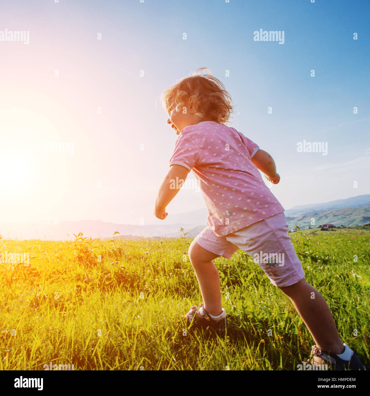 Little toddler girl running in a beautiful field Stock Photo - Alamy