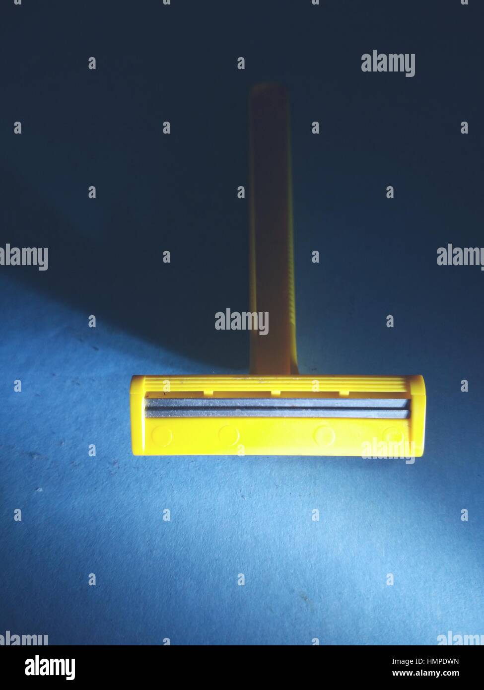 close up of yellow razor isolated on blue background Stock Photo - Alamy