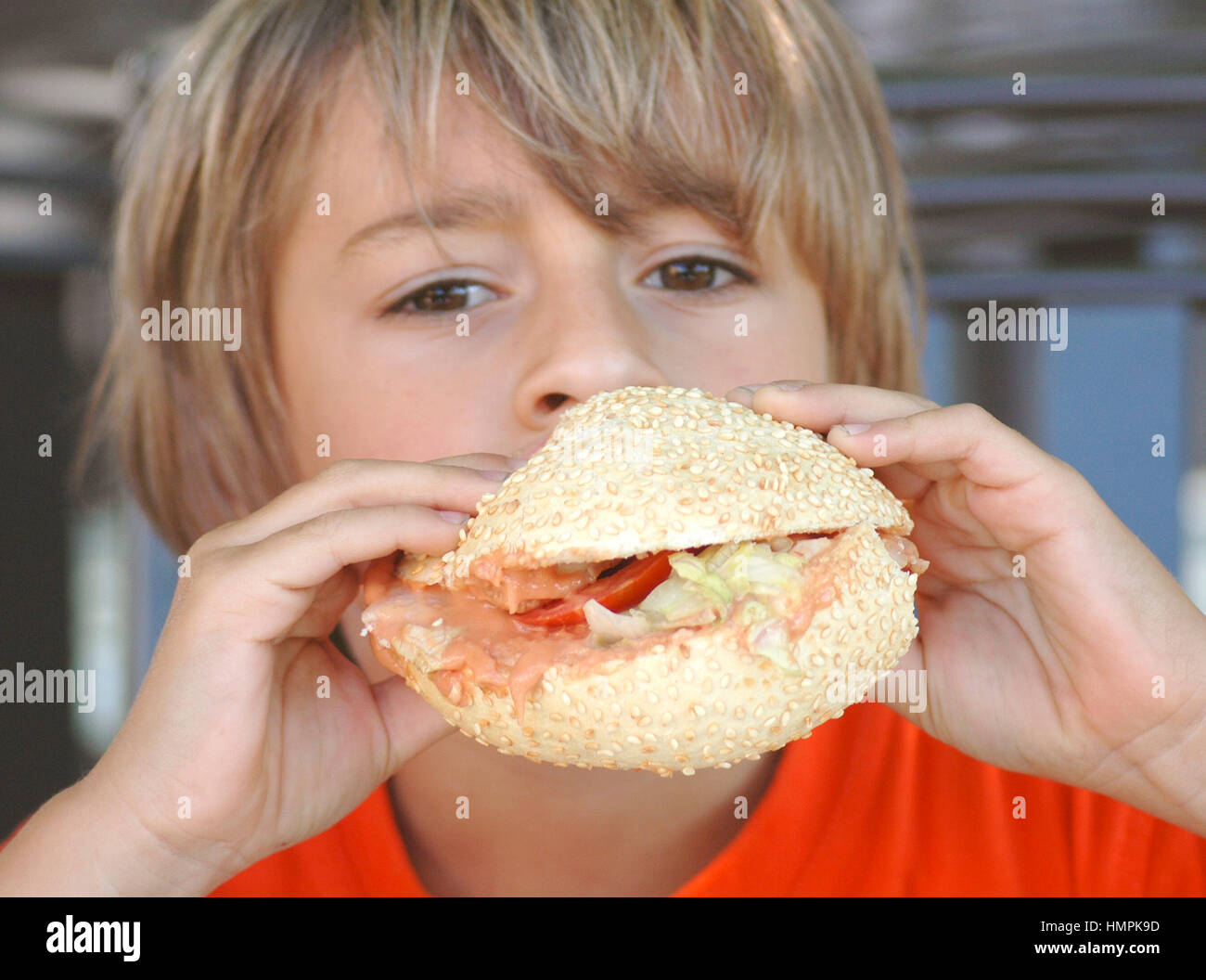 Boy eats burger Stock Photo - Alamy