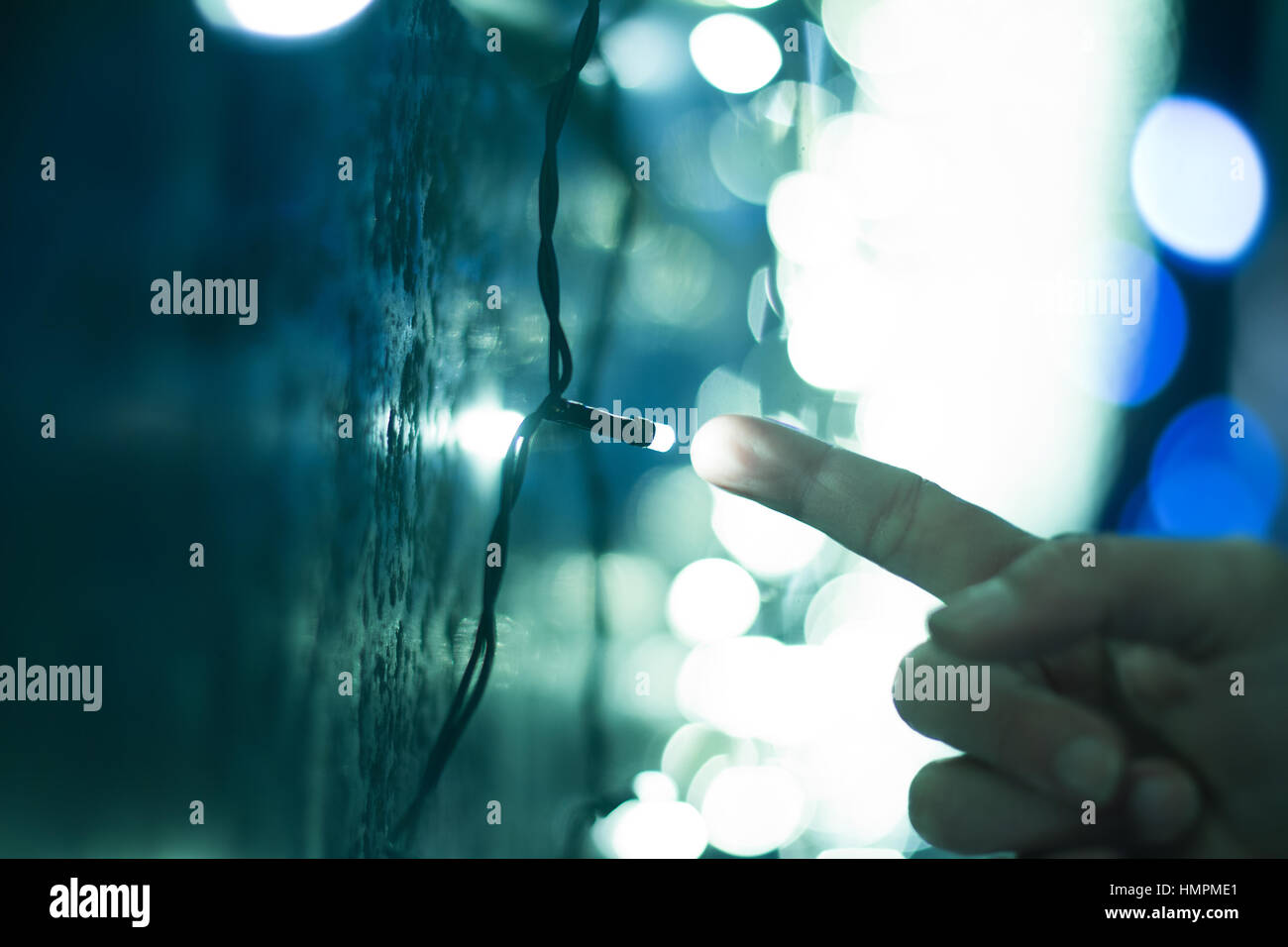 front view close up of finger touching a lone bright led light with ...