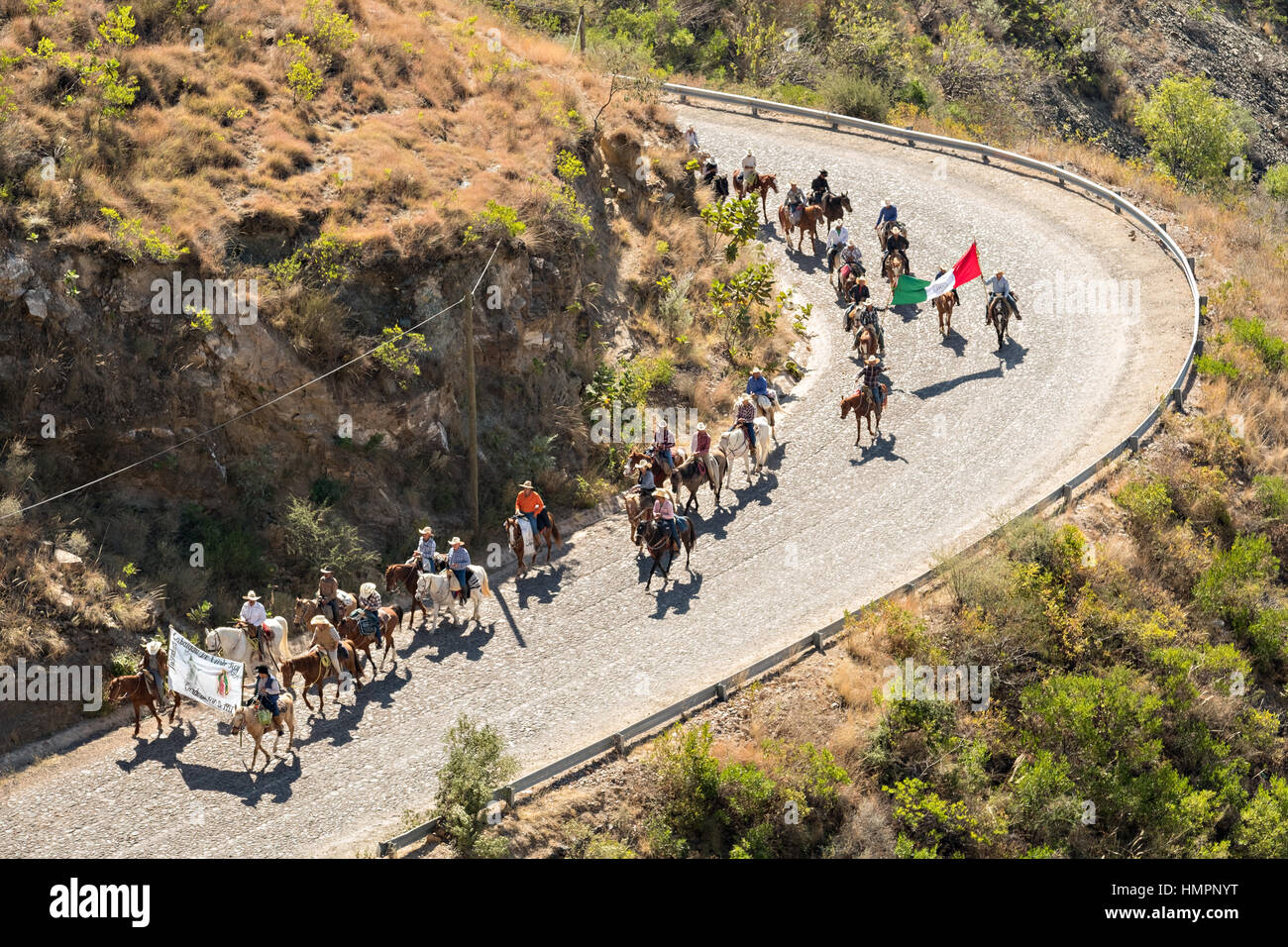 Hundreds of Mexican cowboys snake along the road up Cubilete Mountain ...