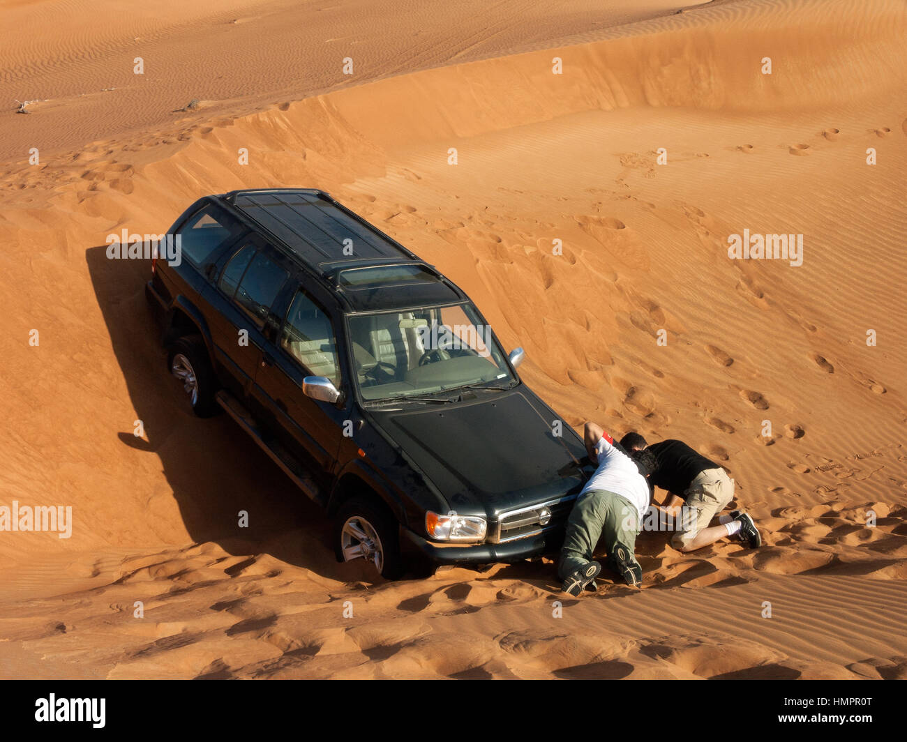 two people trying to rescue stuck 4x4 Stock Photo - Alamy