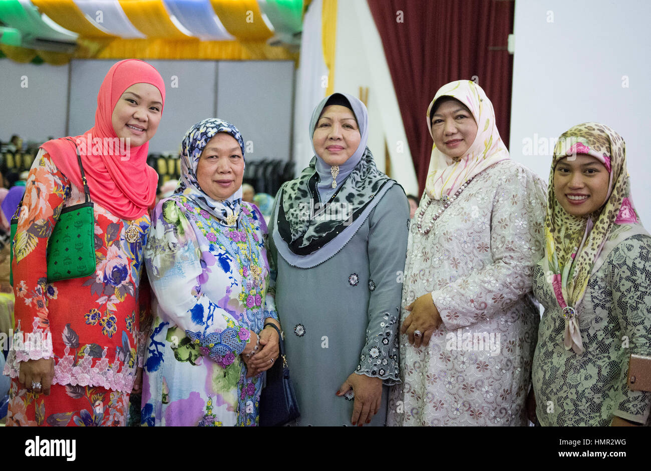 Women in headscarf are posing for a group picture at a wedding ceremony ...