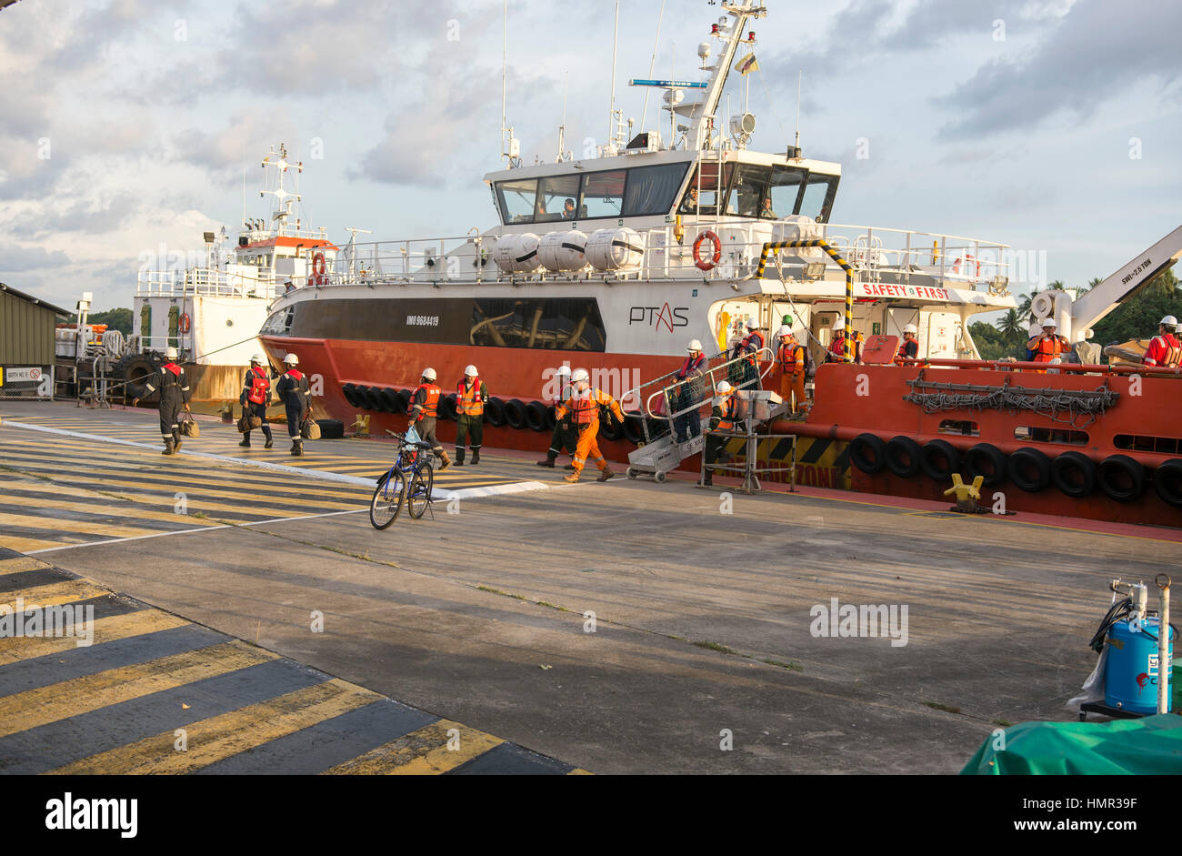 Oil workers in orange overalls are seen transfering from the offshore ...