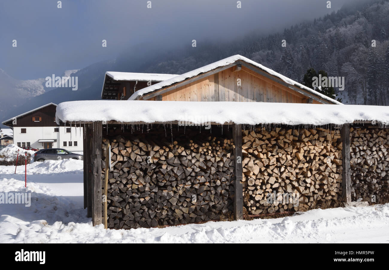 A neat stack of firewood covered in snow Stock Photo - Alamy