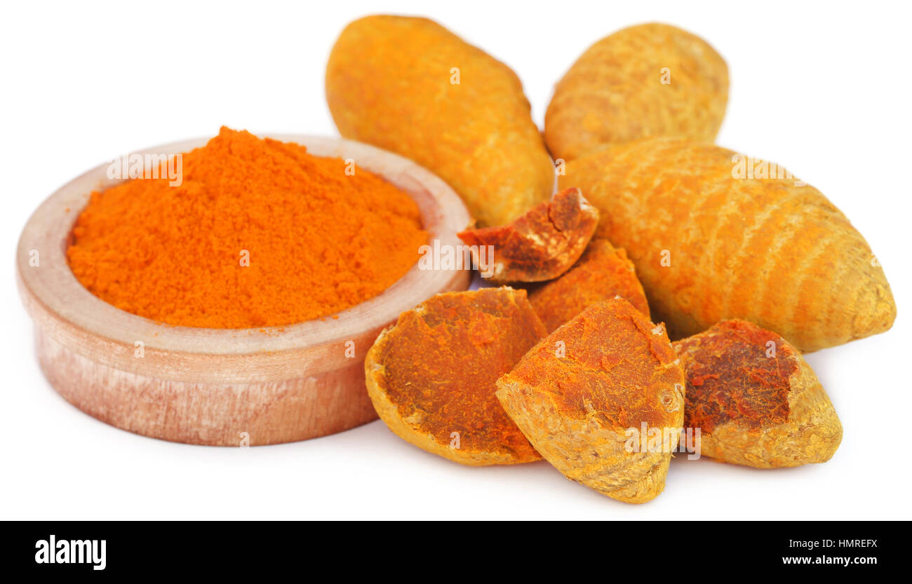 Whole and ground turmeric in bowl over white background Stock Photo - Alamy