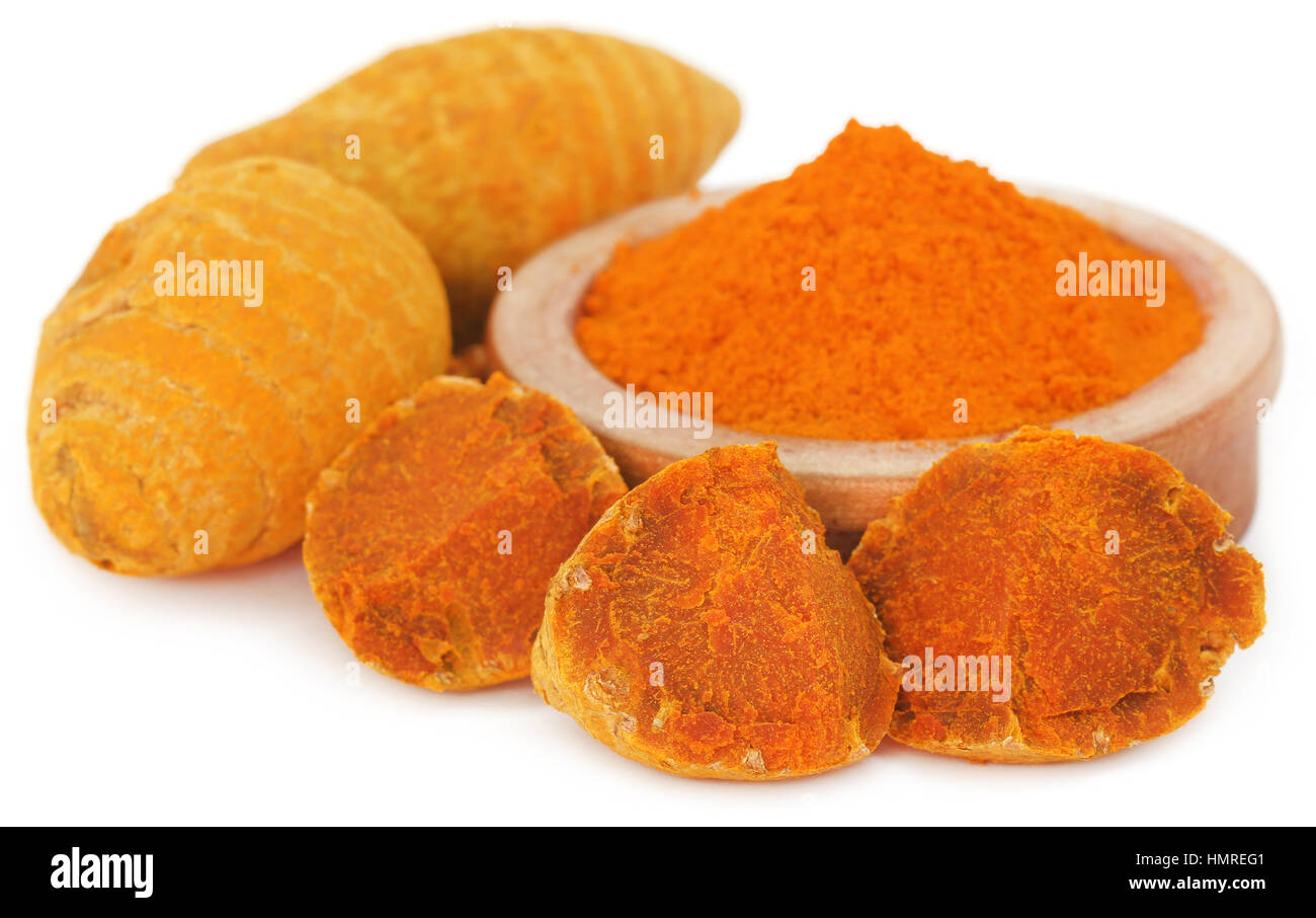 Whole and ground turmeric in bowl over white background Stock Photo - Alamy