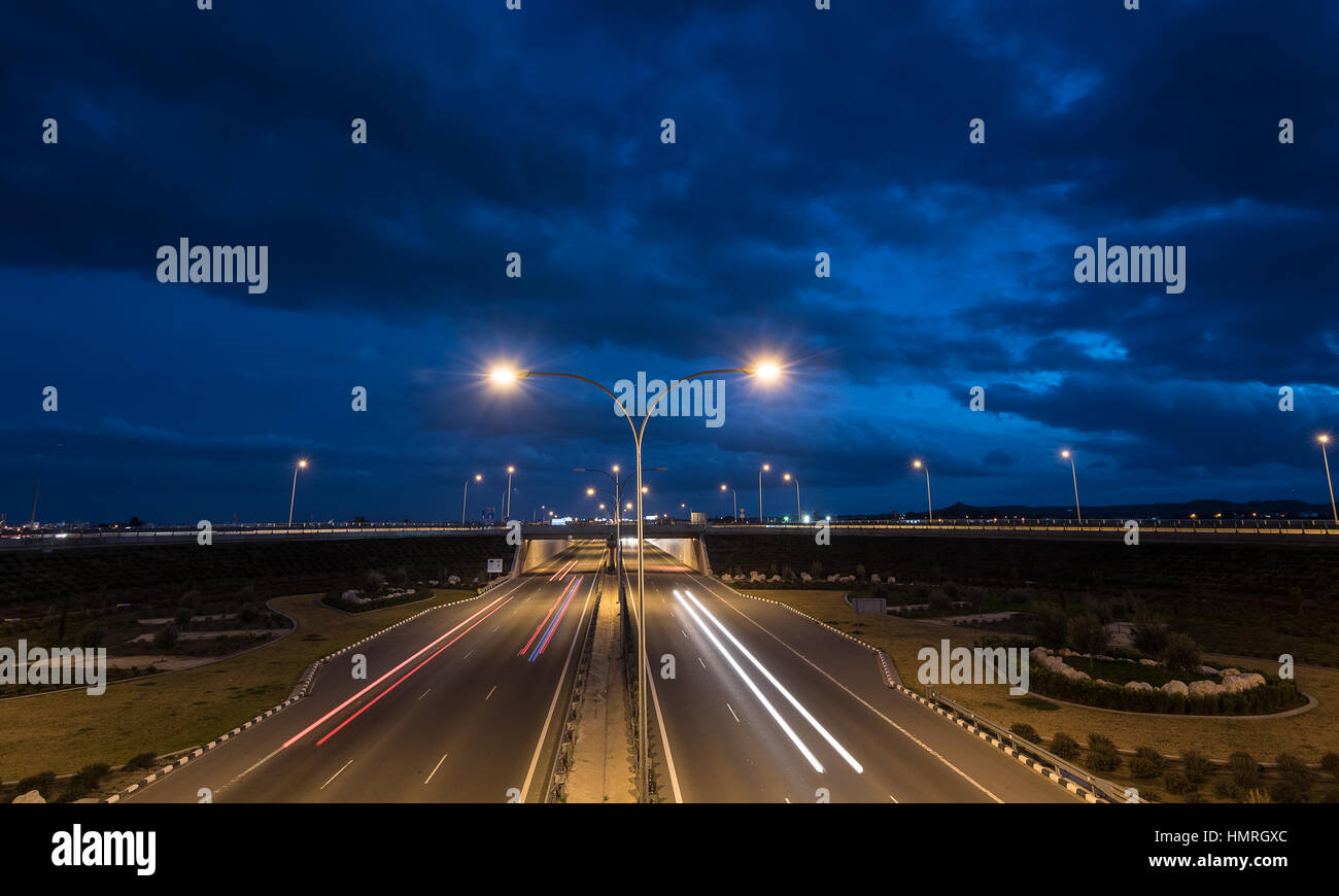 Light trails from cars moving fast late in the evening on a motorway of ...