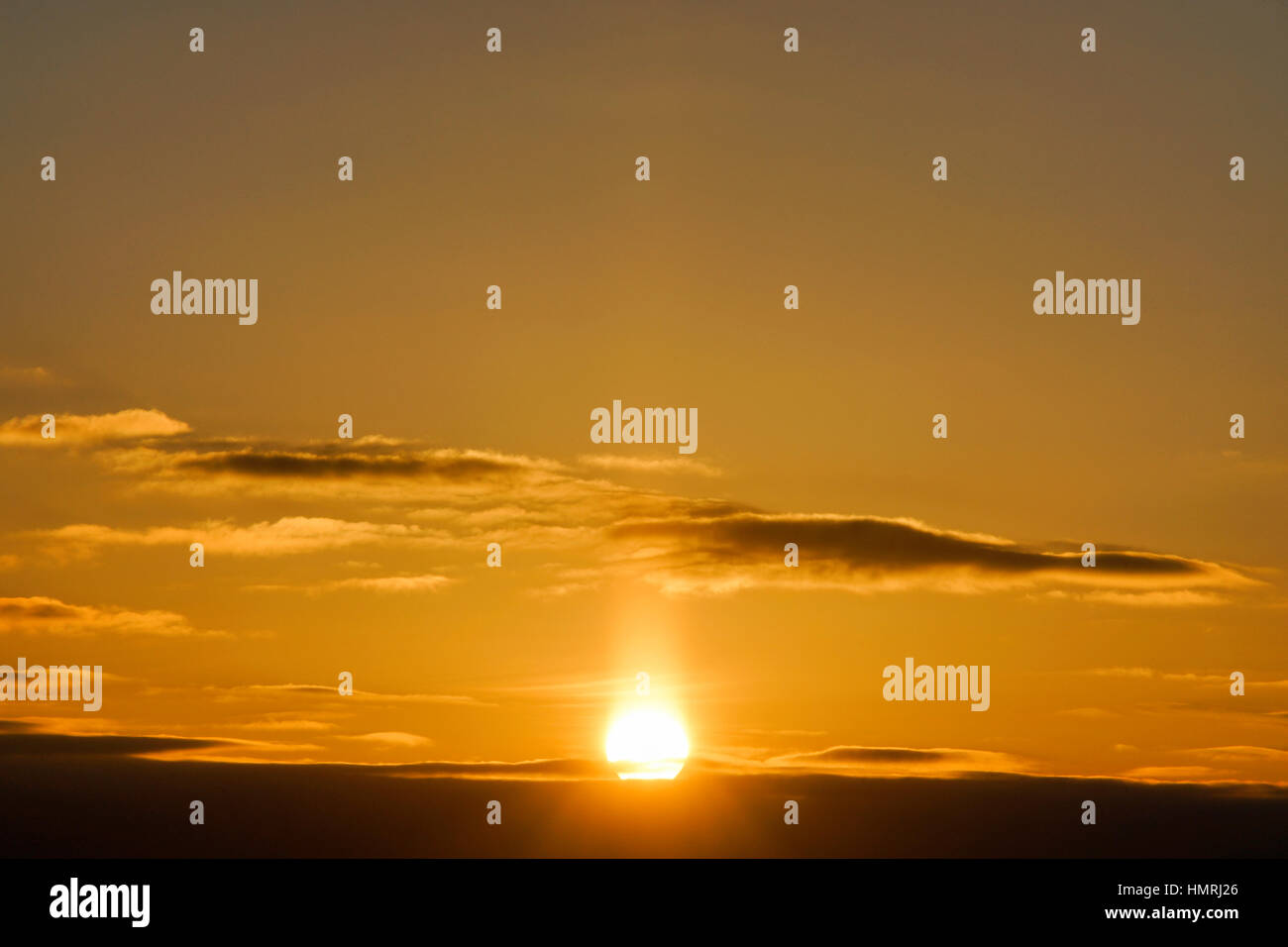 Golden sun rising above clouds, rays bursting, orange glow Stock Photo ...