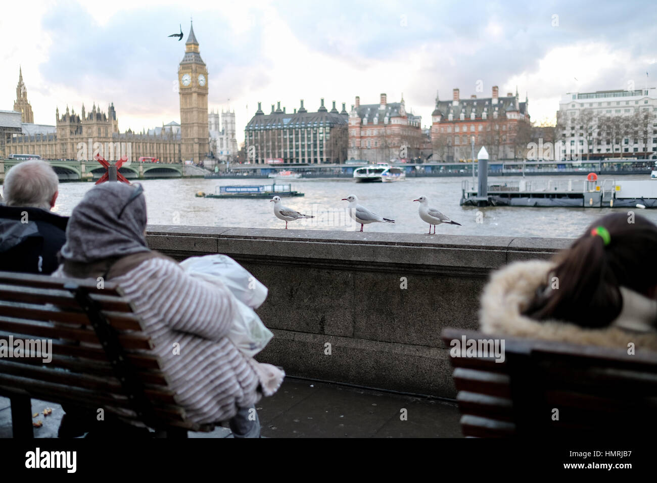 People sitting on the benches at the Bankside; River Thames, Big Ben ...