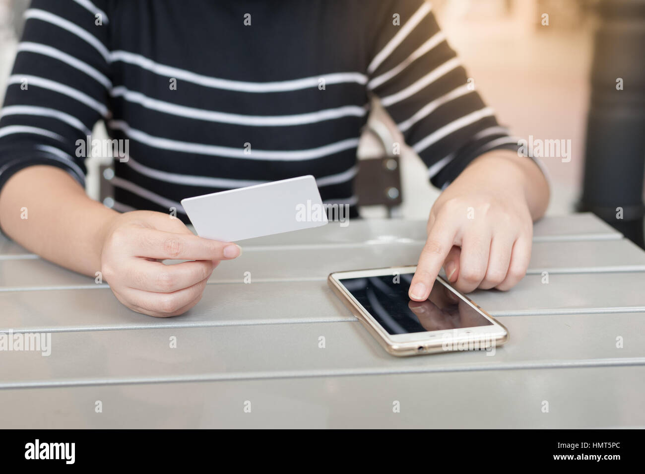 Woman using mobile phone for online shopping payment while another hand ...