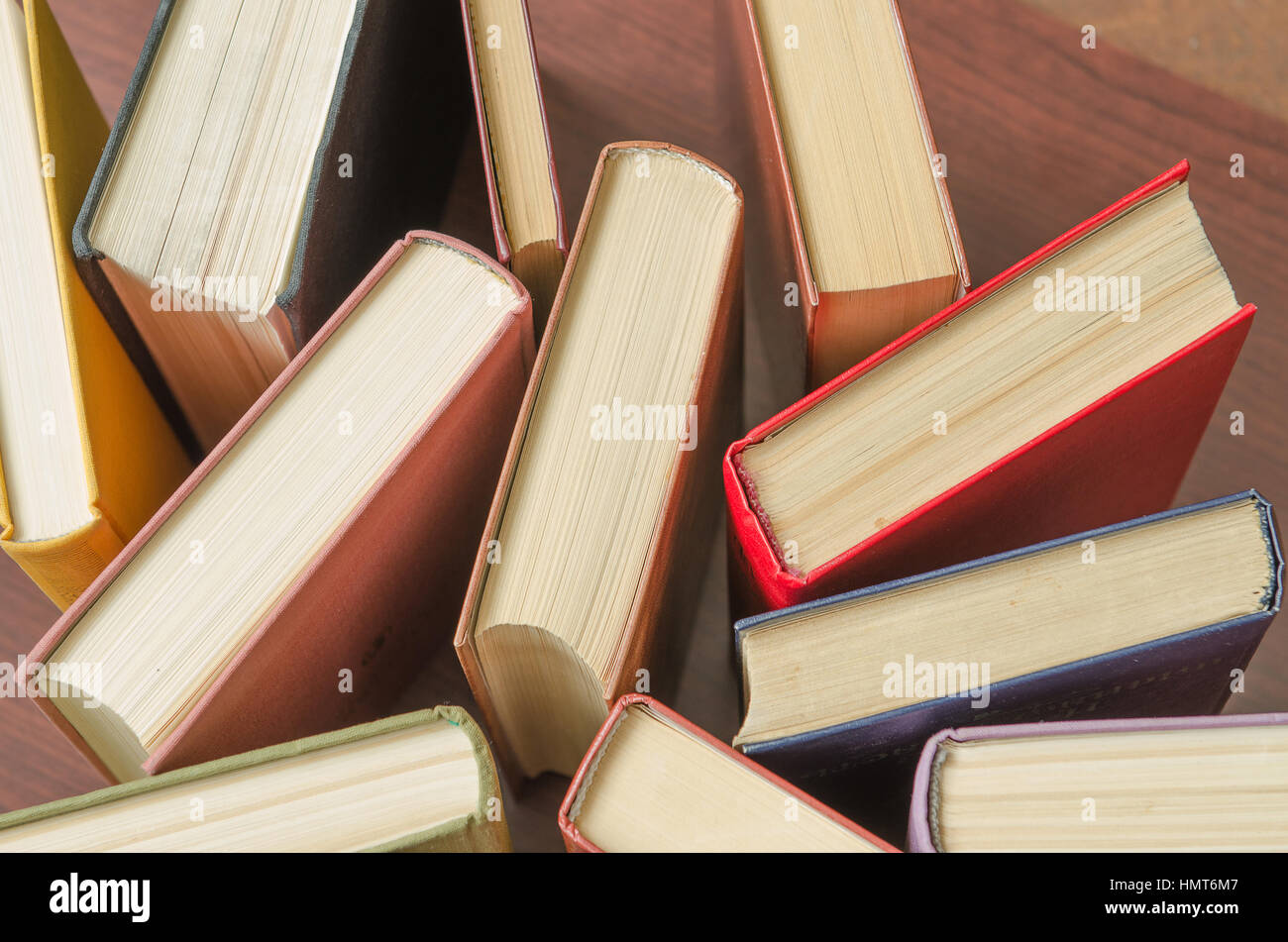 a stack of colorful books in a library or a room Stock Photo - Alamy