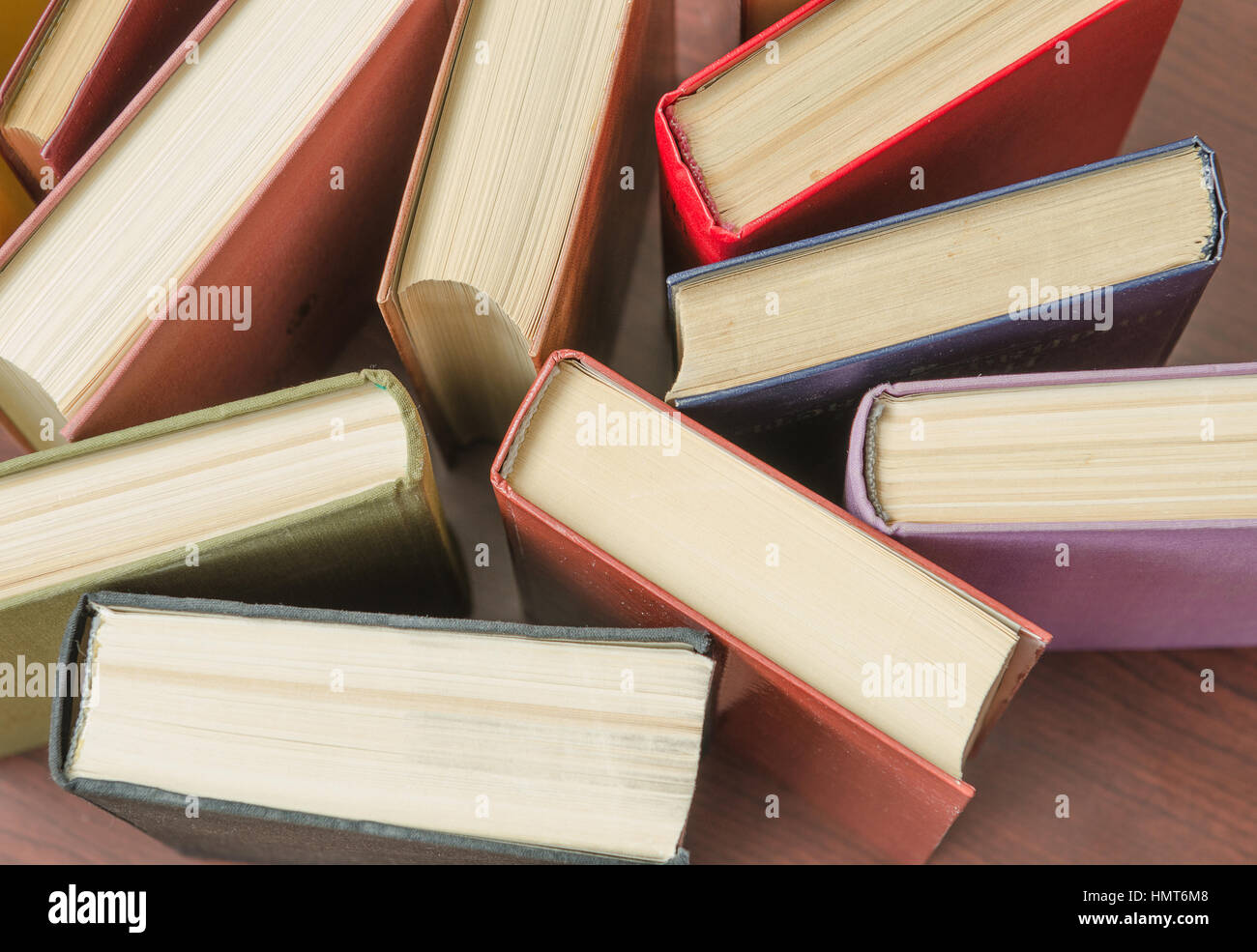 a stack of colorful books in a library or a room Stock Photo - Alamy