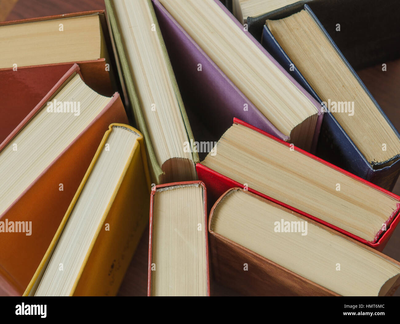 a stack of colorful books in a library or a room Stock Photo - Alamy