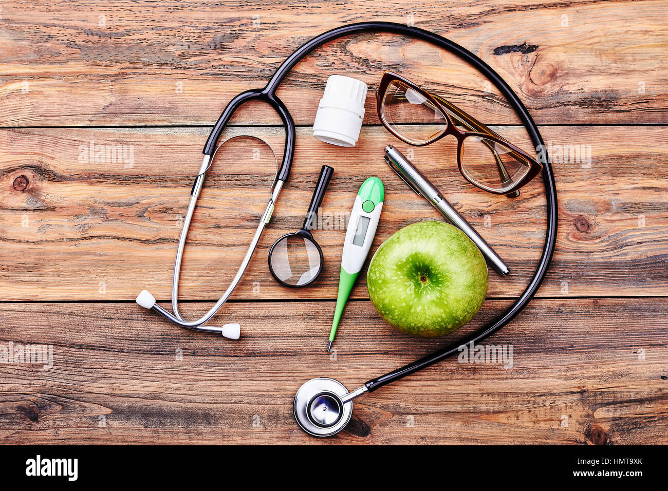 Stethoscope, apple, thermometer and loupe Stock Photo - Alamy
