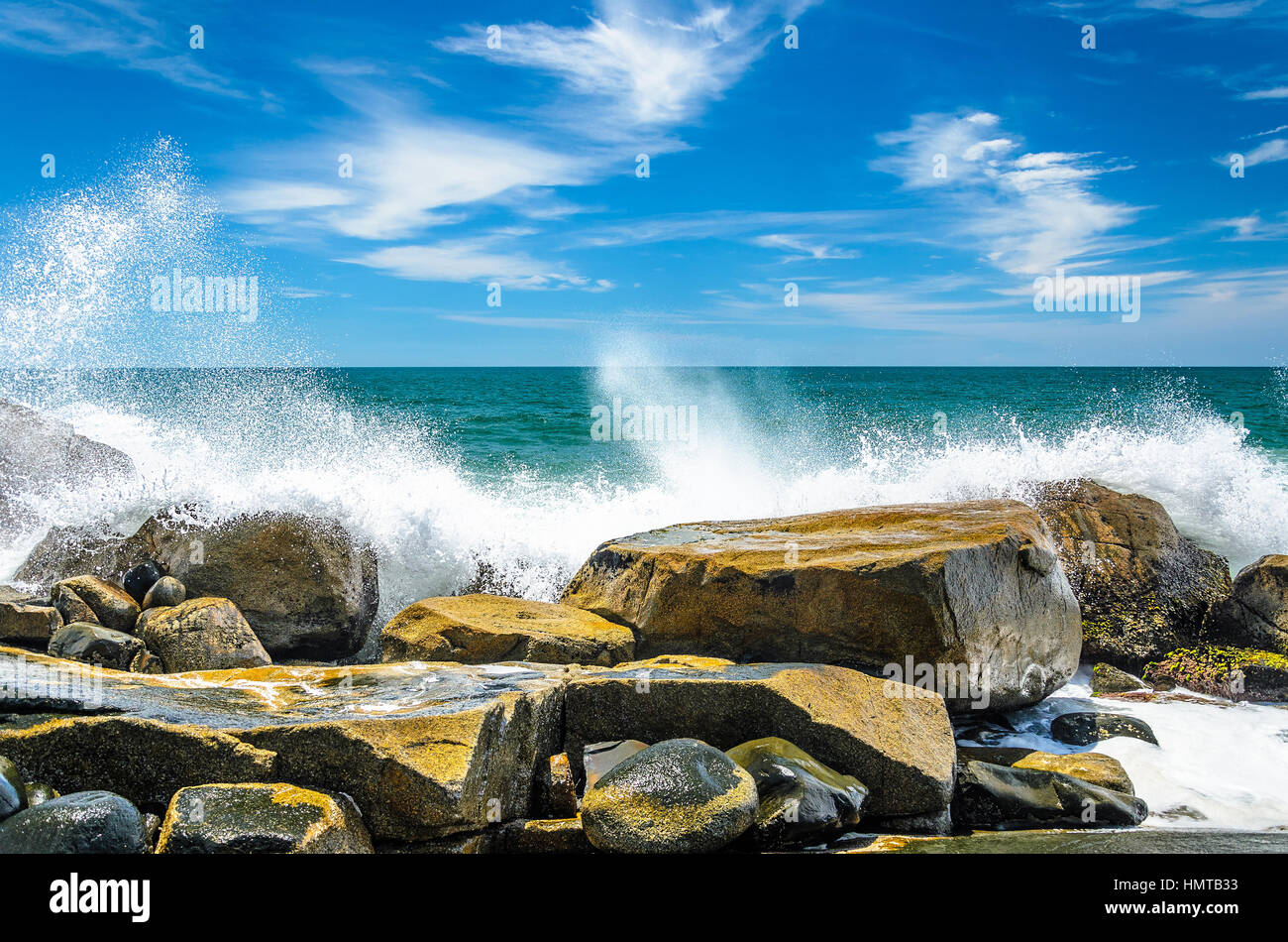 Sea water hitting into rocks on coast and splashing water drops. Rocks ...