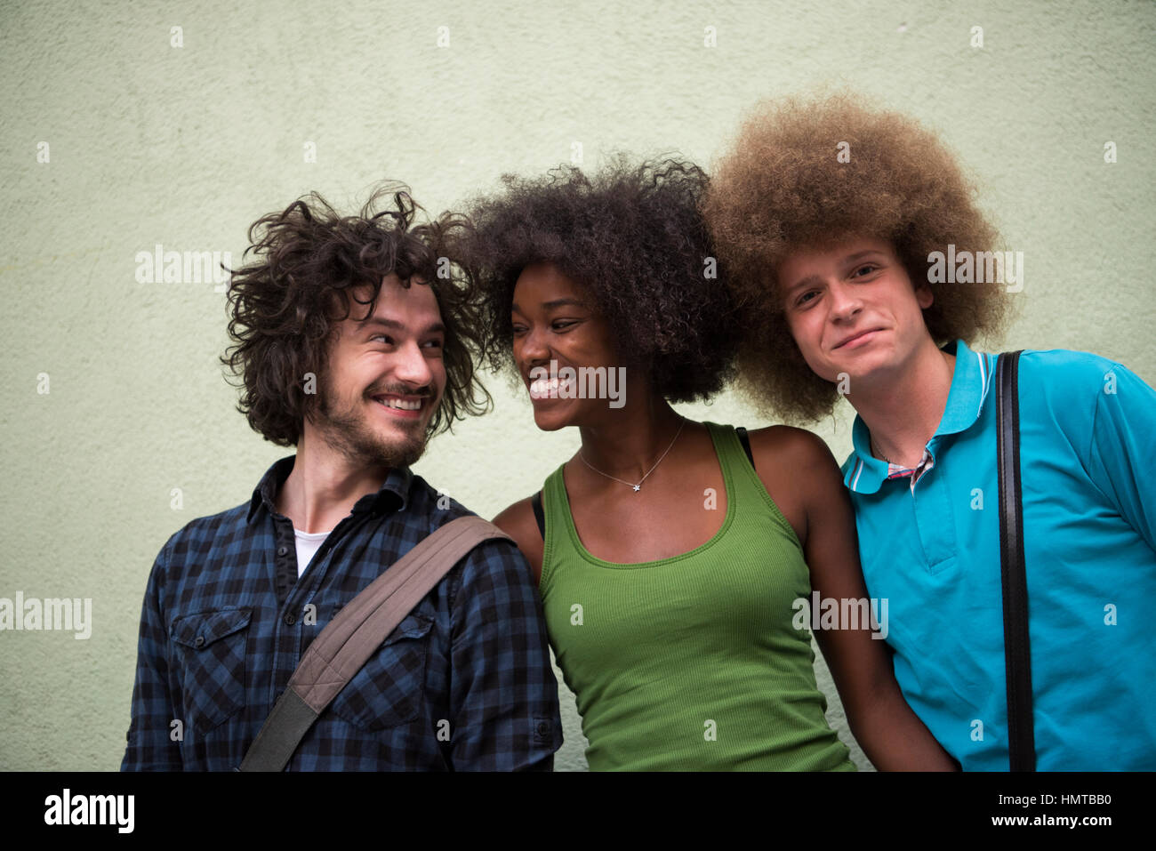 Portrait of multiethnic group of happy three friends in casual wear ...