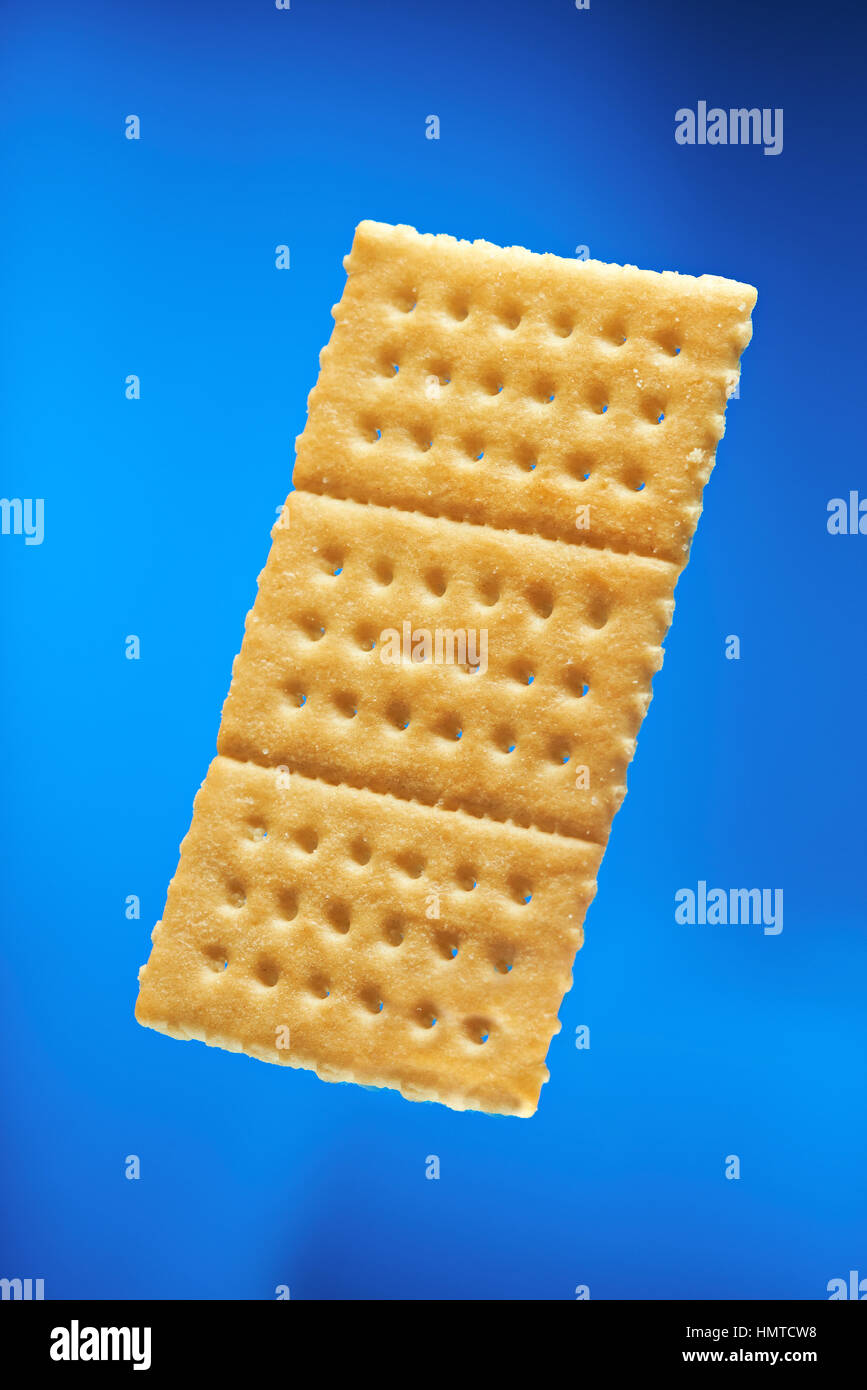 one solty cracker isolated on blue background Stock Photo - Alamy
