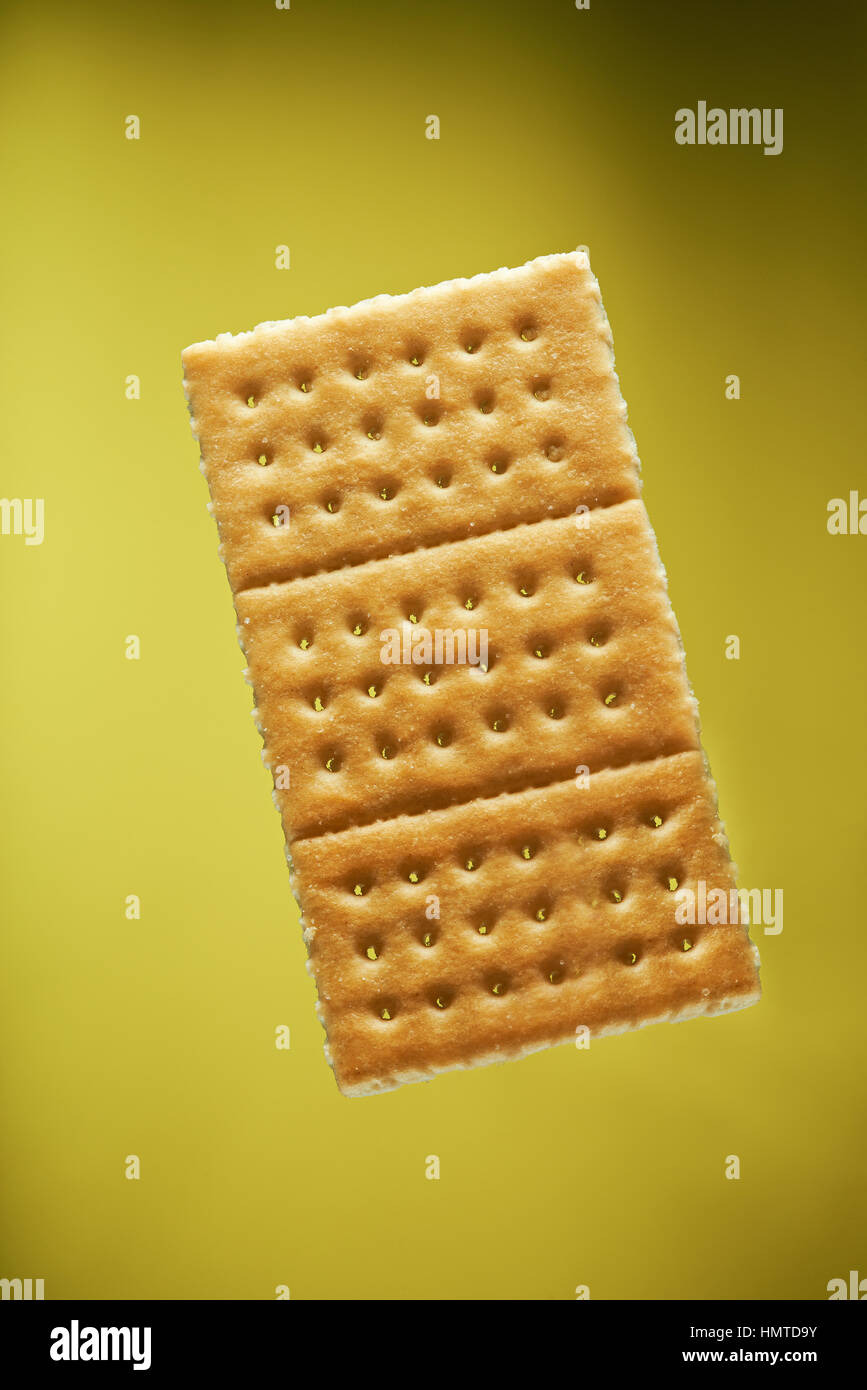 gold cracker cookie isolated on yellow background Stock Photo - Alamy