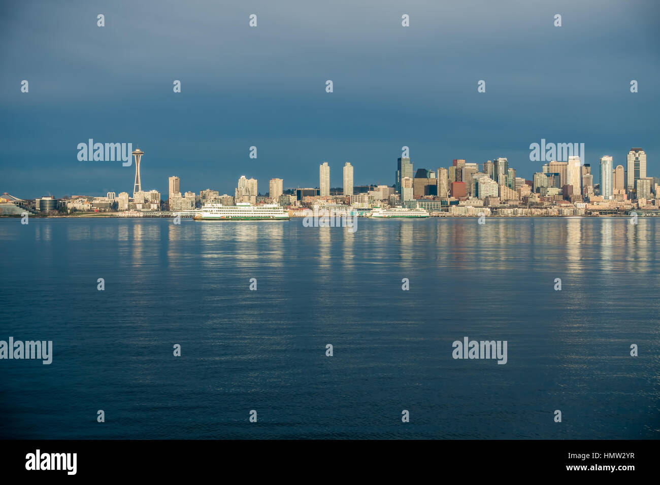As the sun sets the buildings of the Seattle skyline are reflected in ...