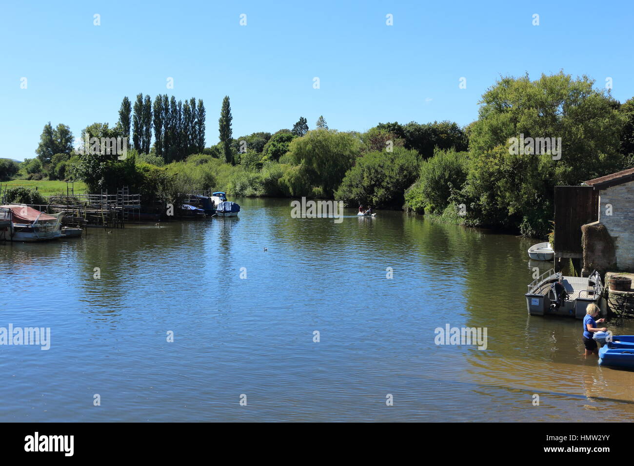 River Frome at Wareham Abbotts Quay on a hot summers day with boats and ...