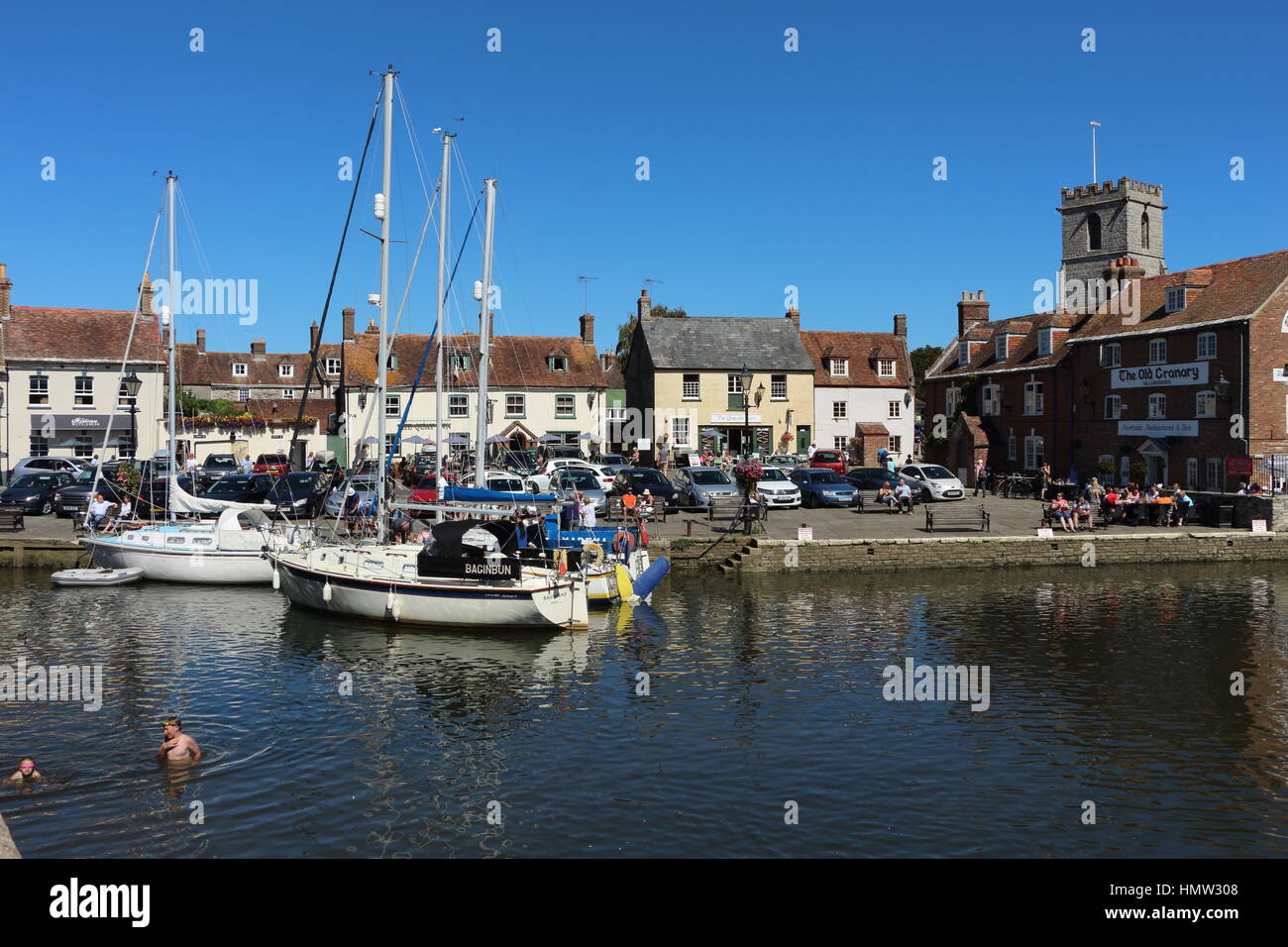 Wareham Quay and Old Granary with moored yachts sunny day with children ...