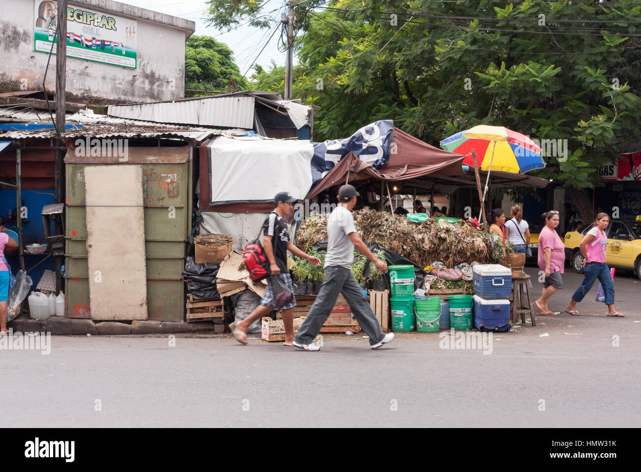 People walk past street vendor stalls of medicinal herbs “yuyos" on the ...
