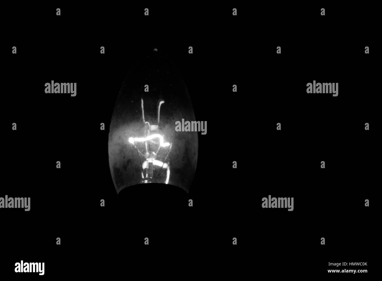 Lit up light bulb and black background Stock Photo - Alamy