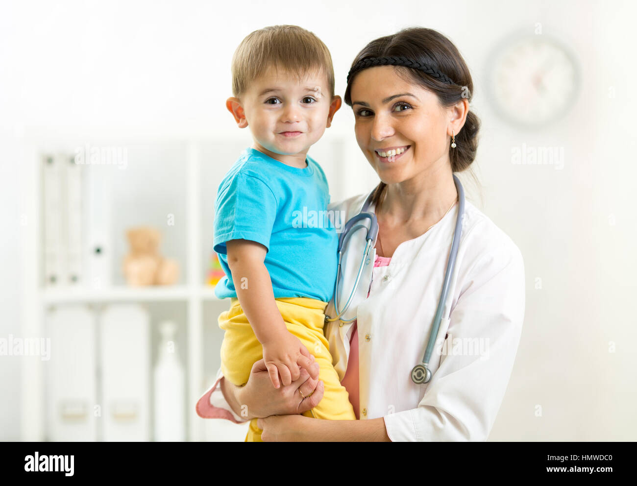 Pediatrician female doctor holding in her hands kid Stock Photo - Alamy