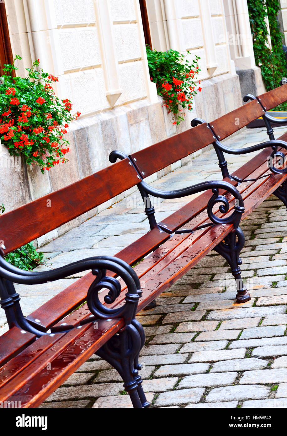 Vintage wooden bench in the street near the wall Stock Photo - Alamy