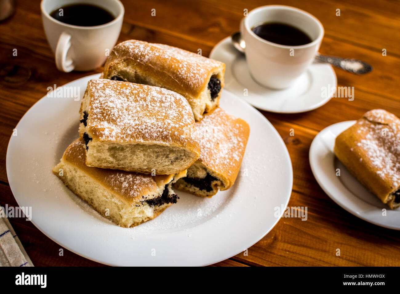 Baked sweet buns with poppy and coffee on wood table Stock Photo - Alamy