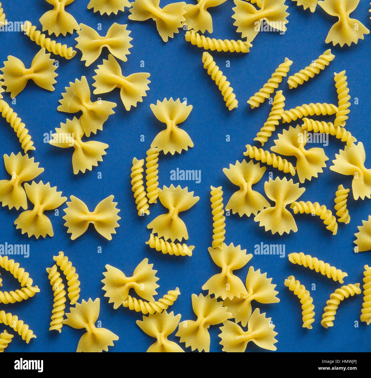 Pasta bow and spiral shape on blue background Stock Photo - Alamy
