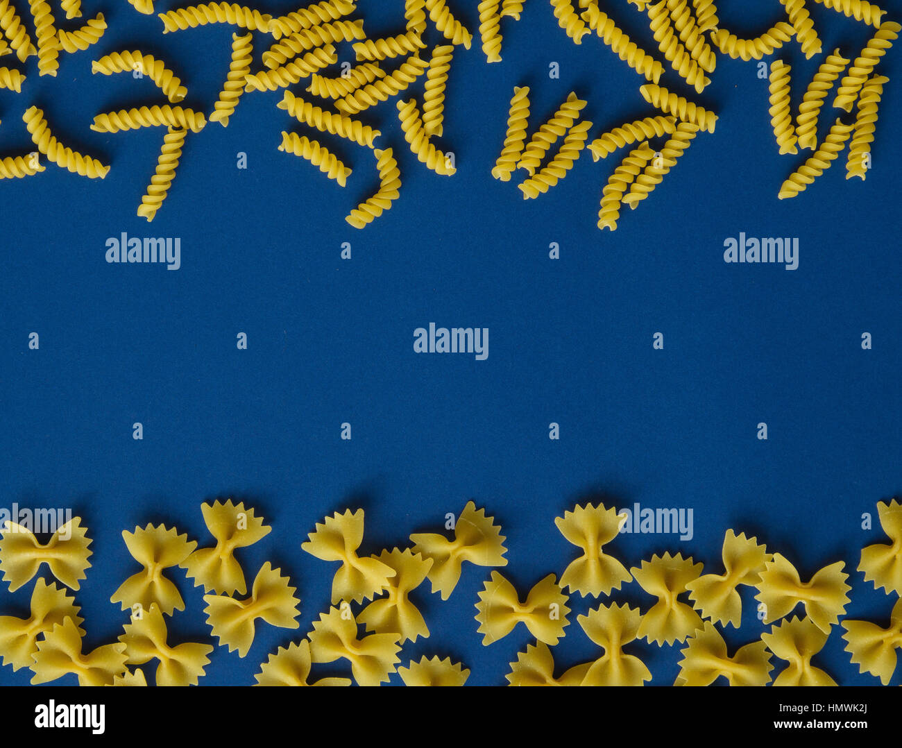 Pasta spiral and bow shape on blue background with plece for text Stock ...