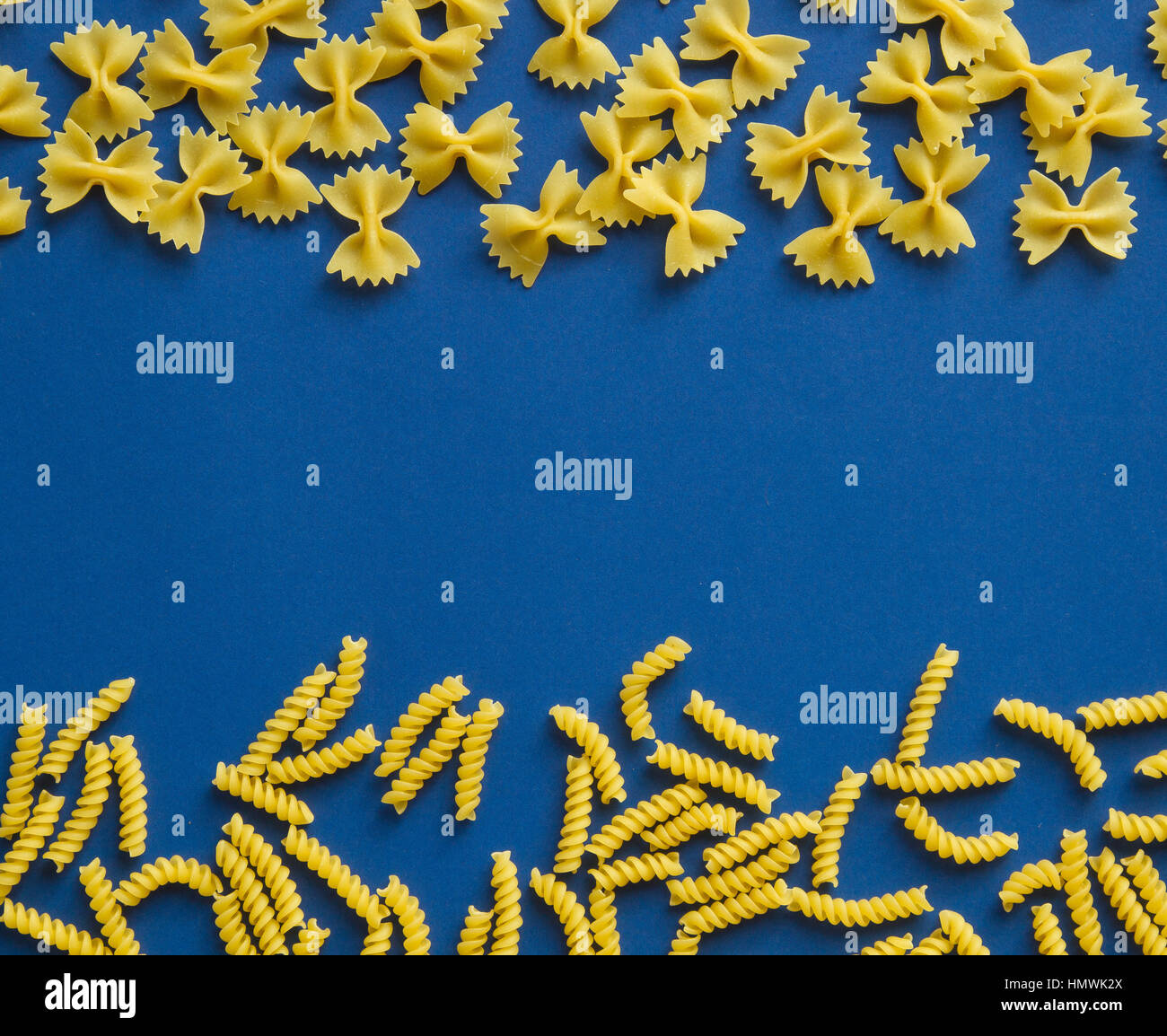 Pasta spiral and bow shape on blue background with plece for text Stock ...