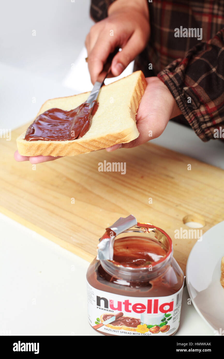 prepare bread with nutella for breakfast at the table Stock Photo - Alamy