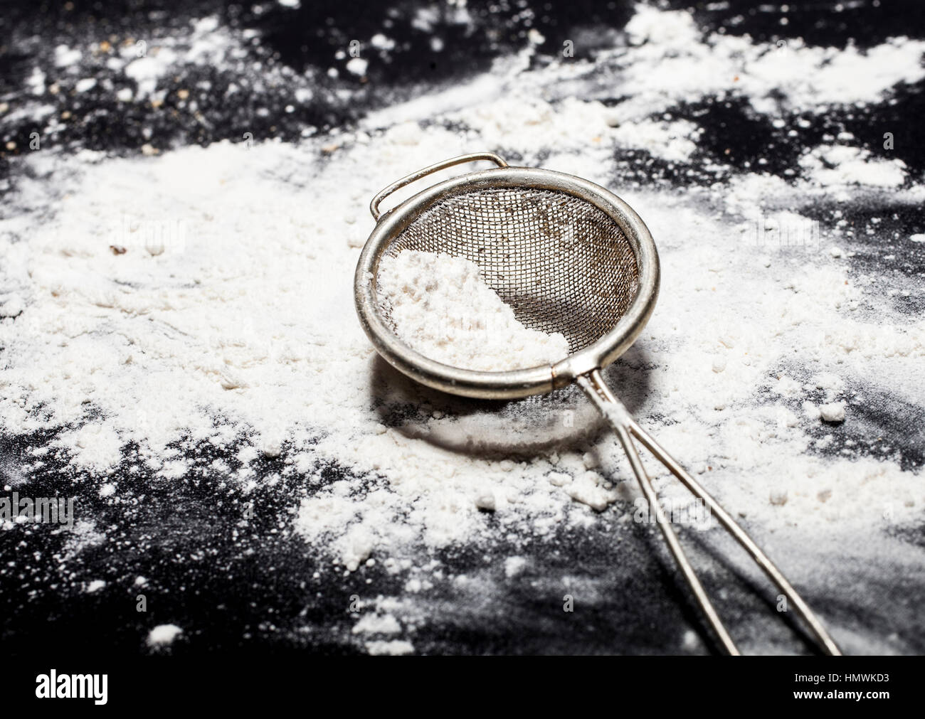 Metal strainer with spilling flour on a black background Stock Photo ...