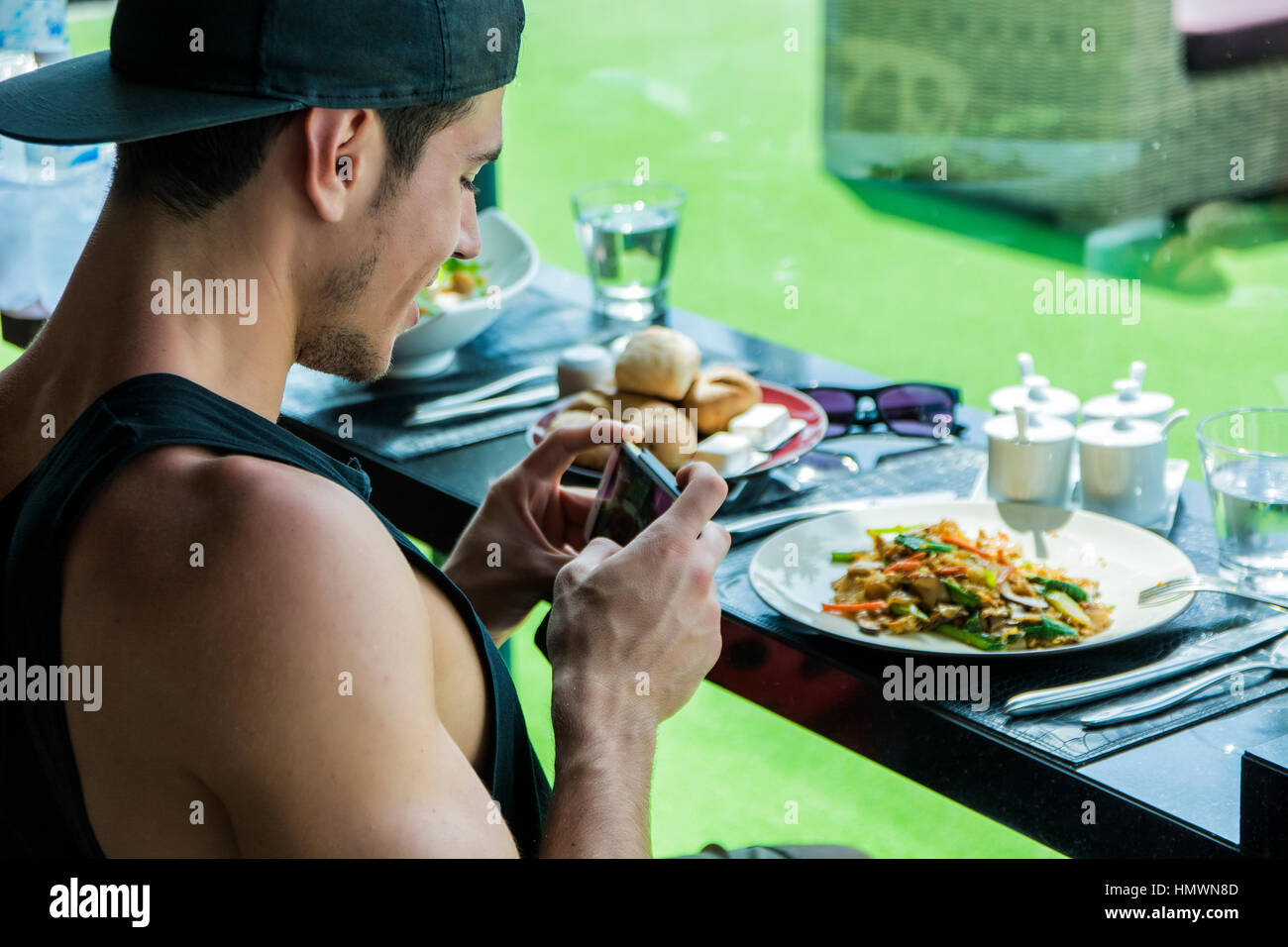 Young man taking photo of food at diner Stock Photo - Alamy