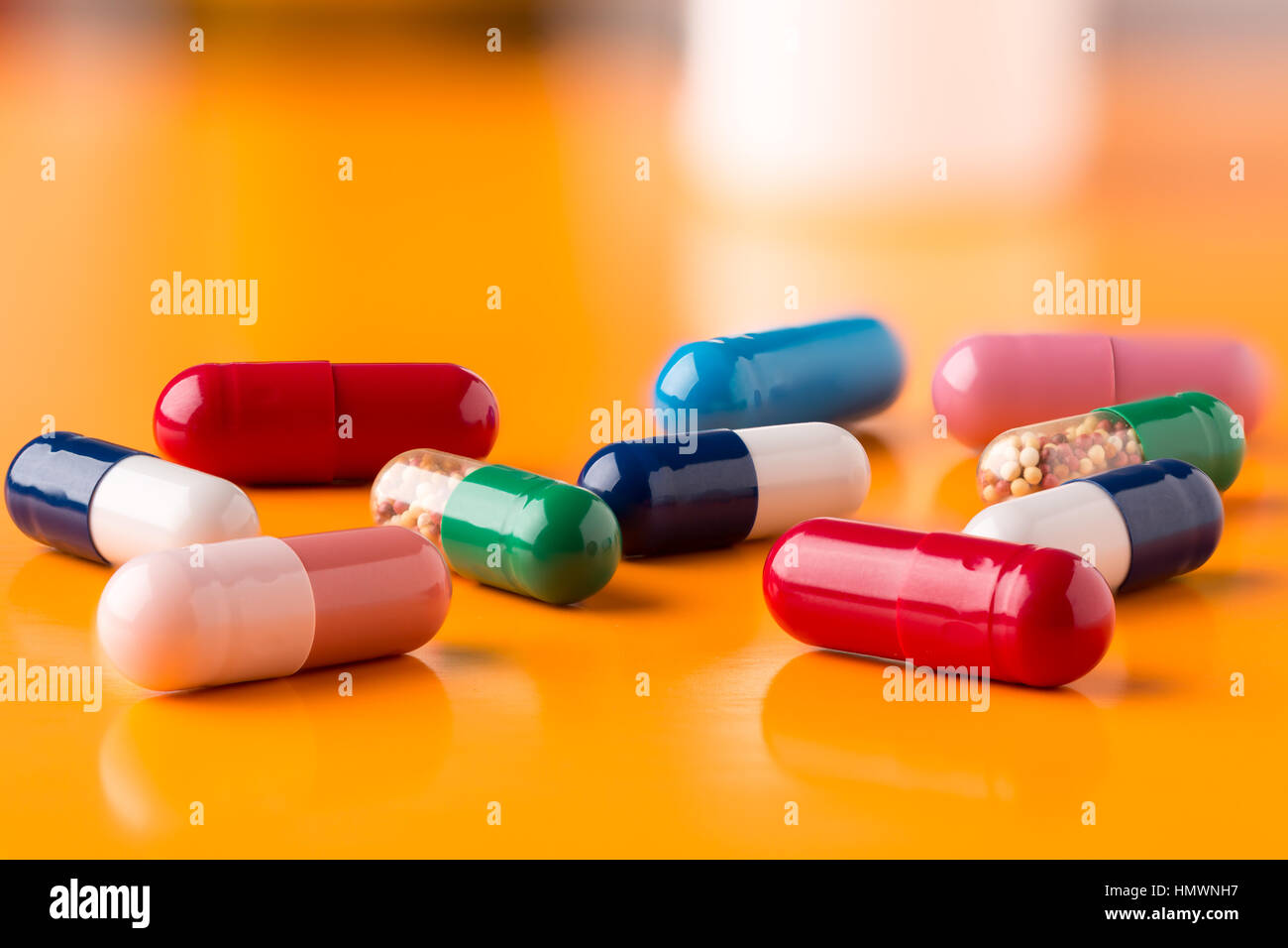 Heap of colorful drugs and pills on orange background Stock Photo - Alamy